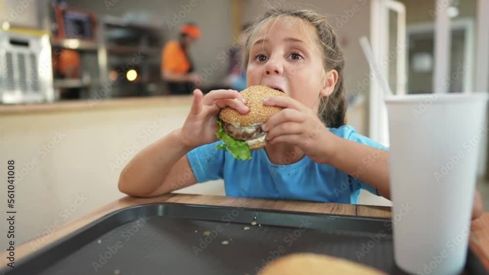 child kid eating a burger in a cafe. fast food nutrition health concept ...