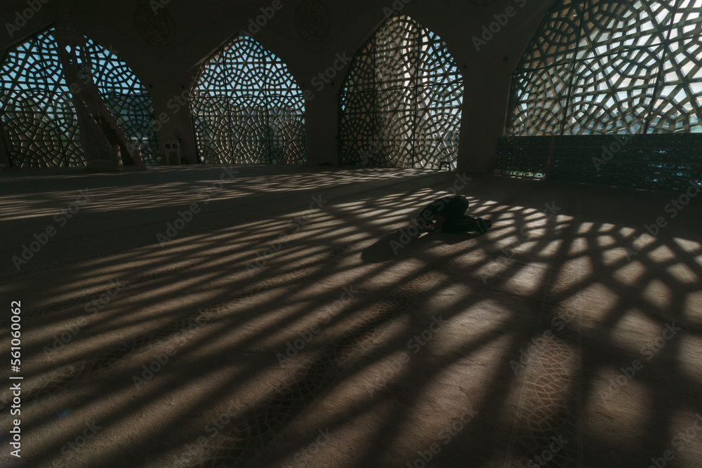 Islamic photo. Muslim man praying in a mosque. Shadows of window on the ...