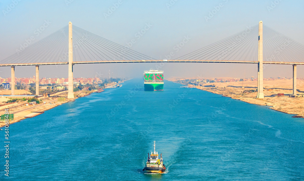 Railway swing bridge over Suez Canal, Egypt Large container ship, accompanied by tugboat ...
