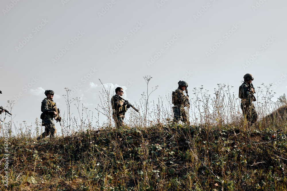 Armed special forces soldiers with rifle going against enemies, in row ...