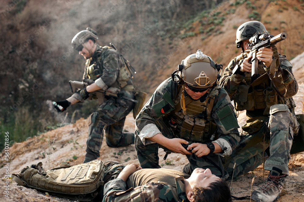 brave army soldiers with injured comrade calling for help, blowing ...