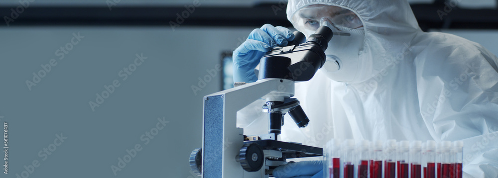 Scientist in protection suit and masks working in research lab using ...