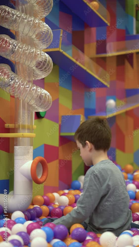A seven-year-old child puts plastic balls into an air tube while ...