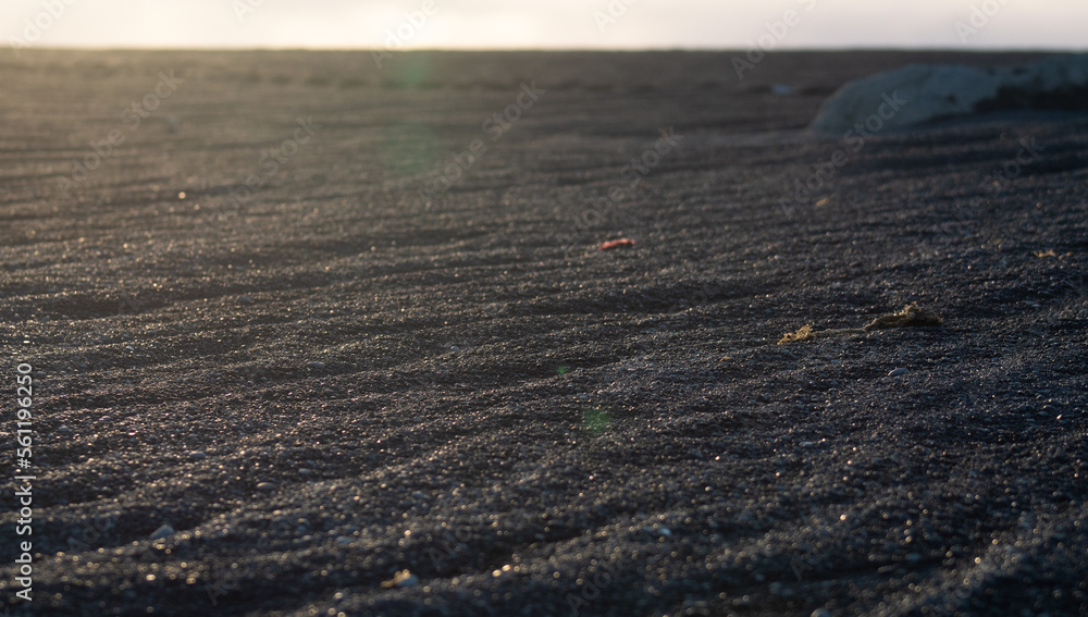 In this picture you can see a black sand beach. The close-up shows fine ...