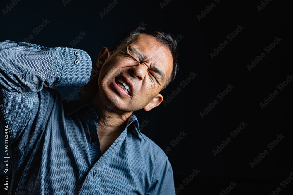 Middle-aged Japanese man in gray casual Y-shirt on dark background ...