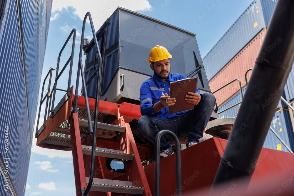 Asian truck driver and worker is looking at his checklist. he is ...