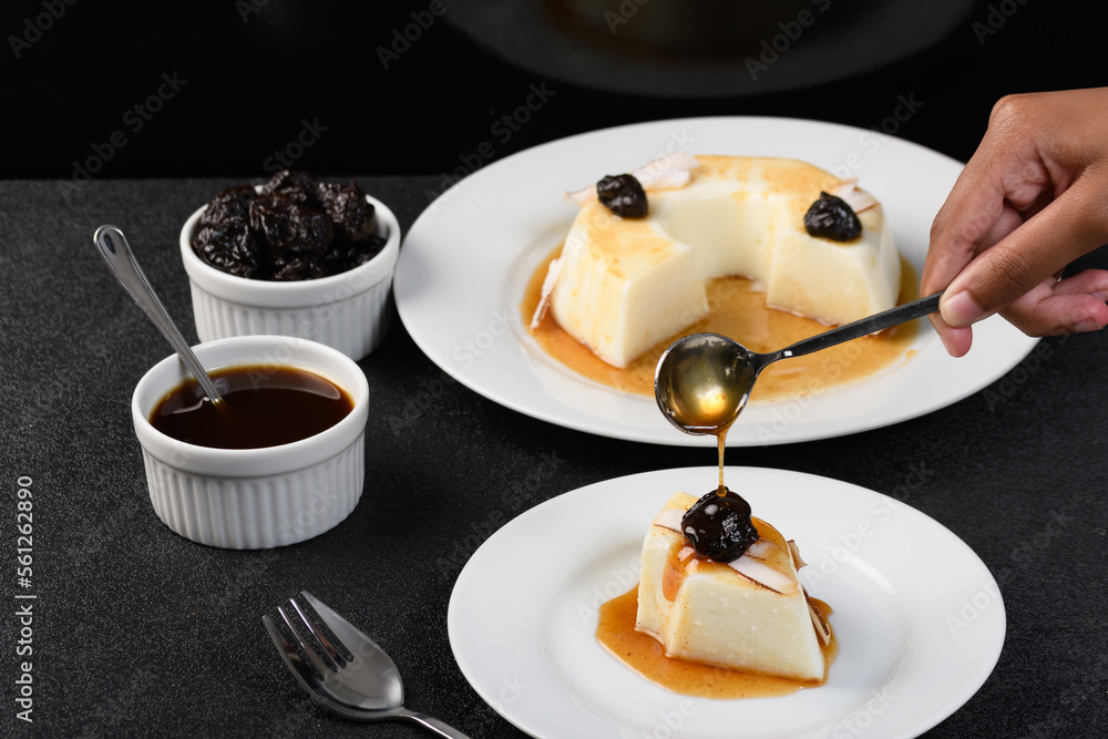 slice of coconut manjar on a white plate, plum syrup falling over the ...