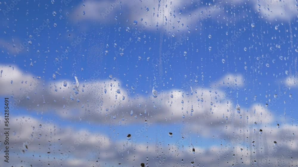 Rain Drops Flow Down Glass Against a Background of Moving Clouds and ...