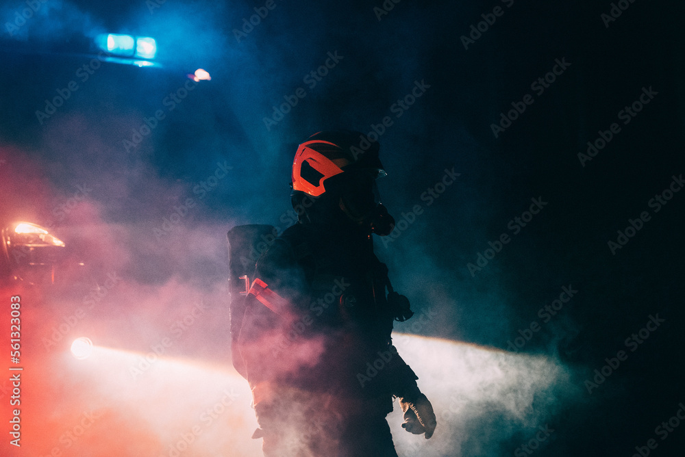 Firefighter in smoke in front of a firetruck. Stock Photo | Adobe Stock
