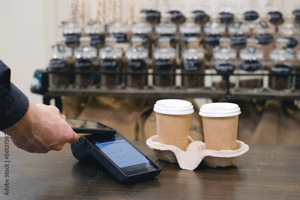 Customer using smartphone and nfs technology to pay barista for ...