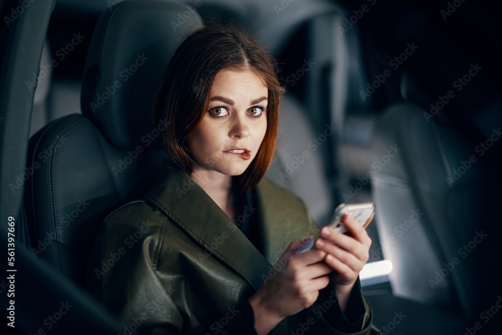 horizontal portrait of a stylish, luxurious woman in a green leather ...