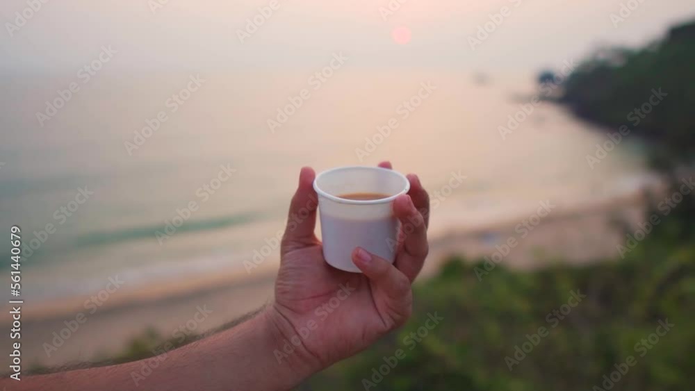Closeup shot of hand of an Indian man holding tea cup in front of the ...