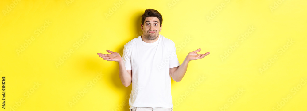 Clueless man shrugging, spread hands sideways confused, dont know ...