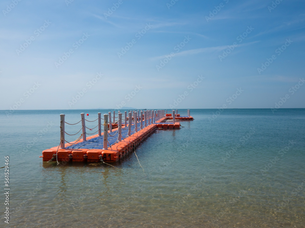 Orange and blue plastic floating pier with protection fence in the sea ...