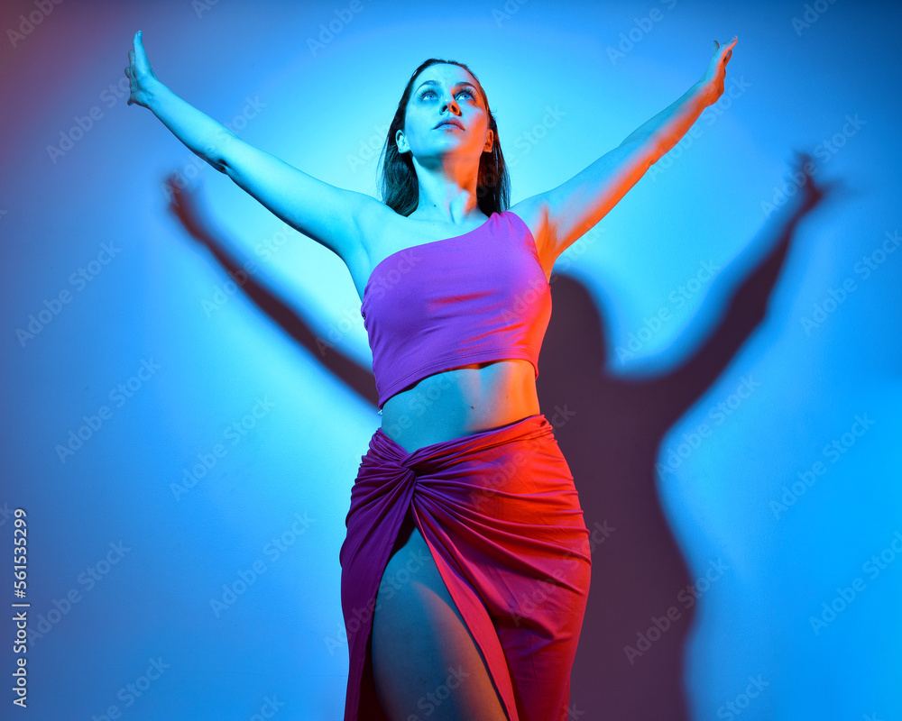 Low angle portrait of pretty girl wearing pink outfit, gestural arm ...