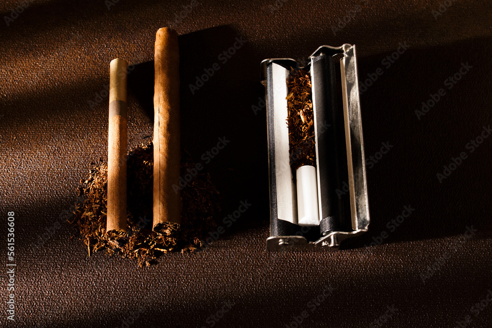Hand-rolled cigarette, rolling machine, cigarillos, scattered tobacco ...