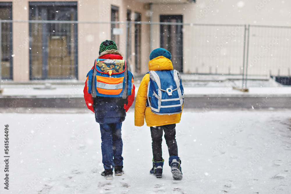 Two little kids boys of elementary class walking to school during ...