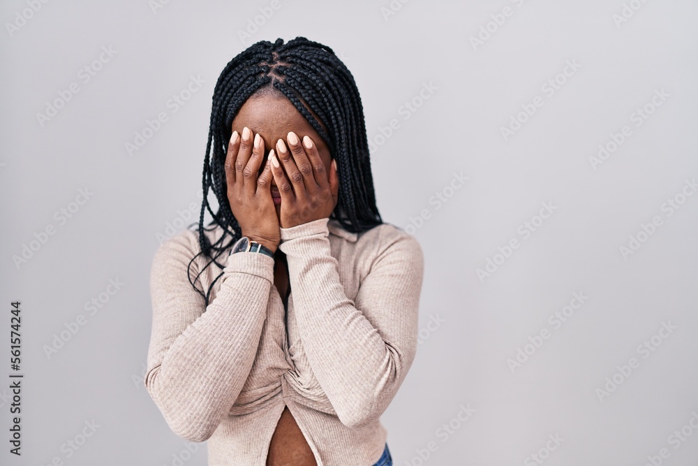 African woman with braids standing over white background with sad ...
