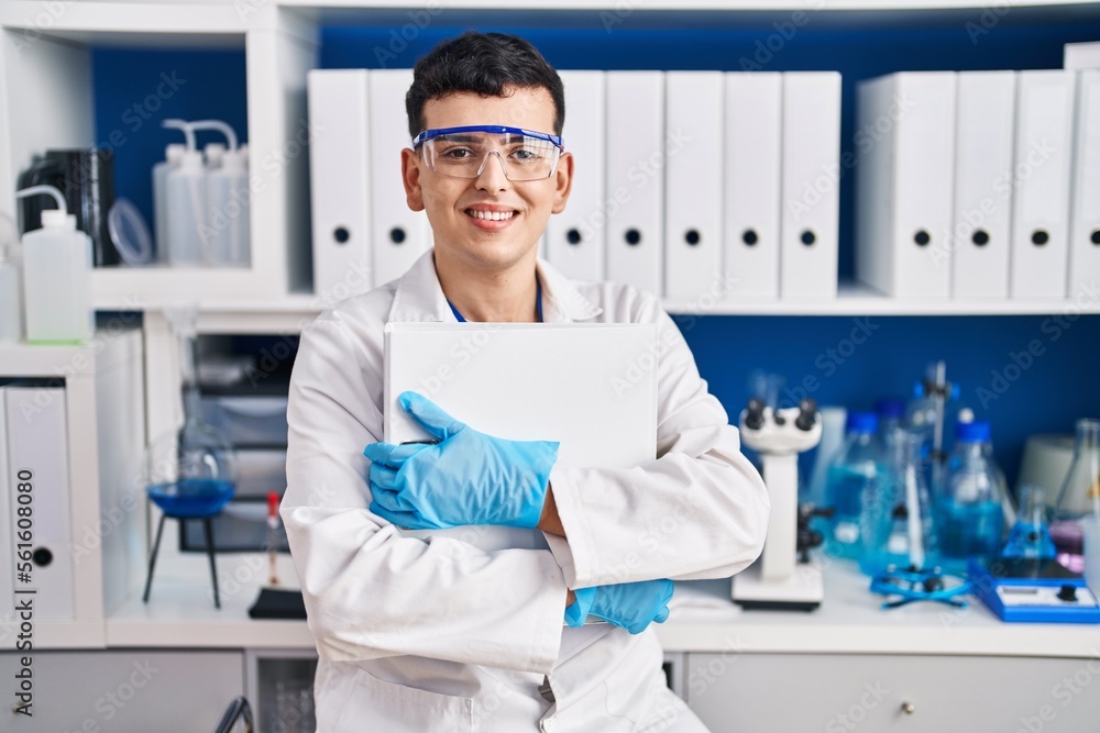 Young non binary man scientist smiling confident hugging binder at laboratory Stock Photo ...