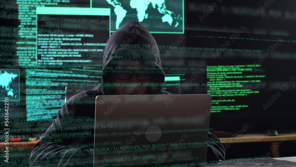 Asian Male Hacker In A Hood Showing Hand Palm To Camera While Works On A Laptop With Maps And ...