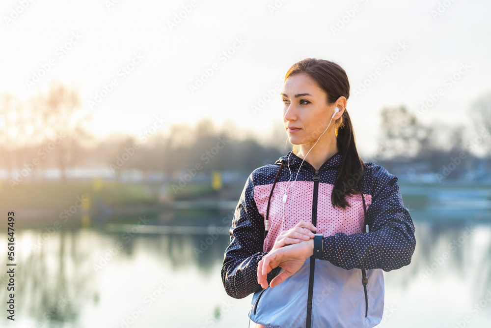 Beautiful woman athlete in a sportswear and headphones getting ready ...