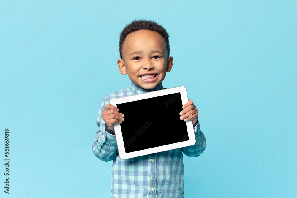 Cute african american kid boy holding digital tablet with blank black ...