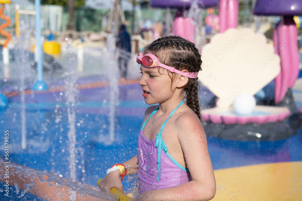 Foto de A child is playing in a water park. A little girl in a purple ...