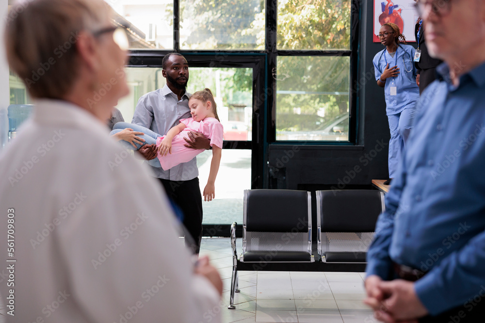 Worried dad entering in hospital waiting room holding unconscious ...