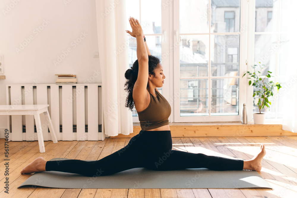 Side view of african american flexible pregnant woman doing yoga splits ...