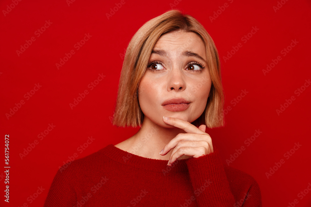 Young blonde woman with short hair expressing perplexity while thinking ...