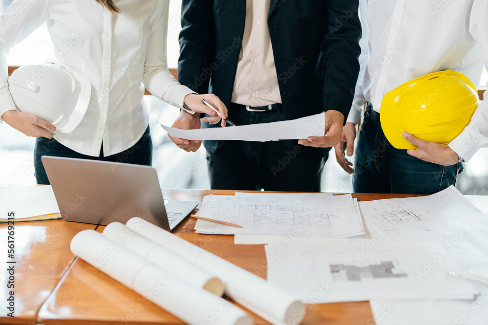 Half body shot of 3 architects or engineers, male and female, working ...