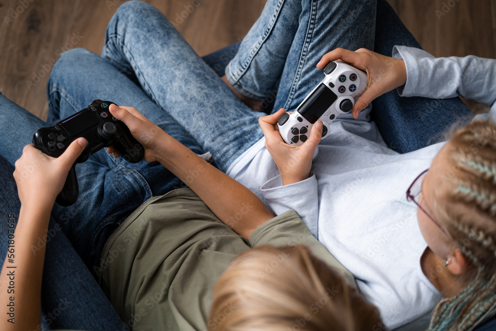 boy and girl playing video game console using joystick or controller ...