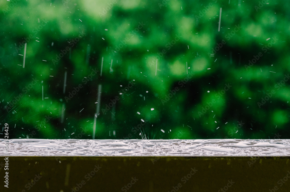 Cinematic shot of raindrops falling from the grey skies and onto the ...