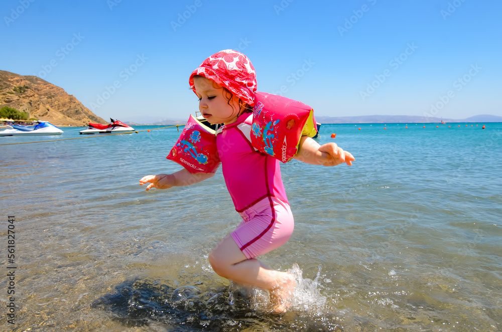 Little girl splashing in the crystal clear water in a lagoon Stock ...
