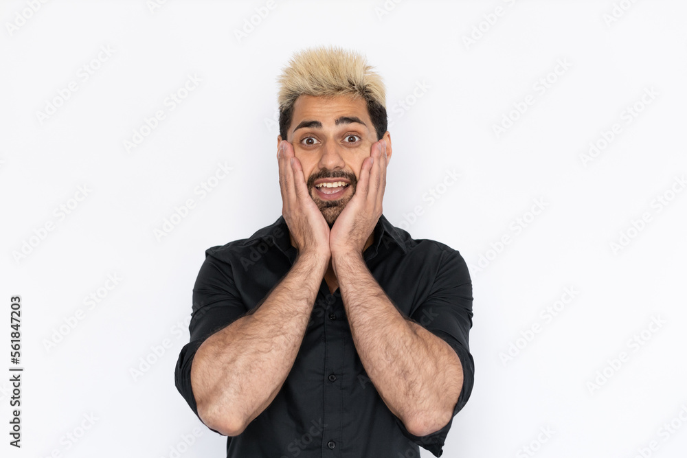 Surprised young man holding his face with hands from shock. Male ...