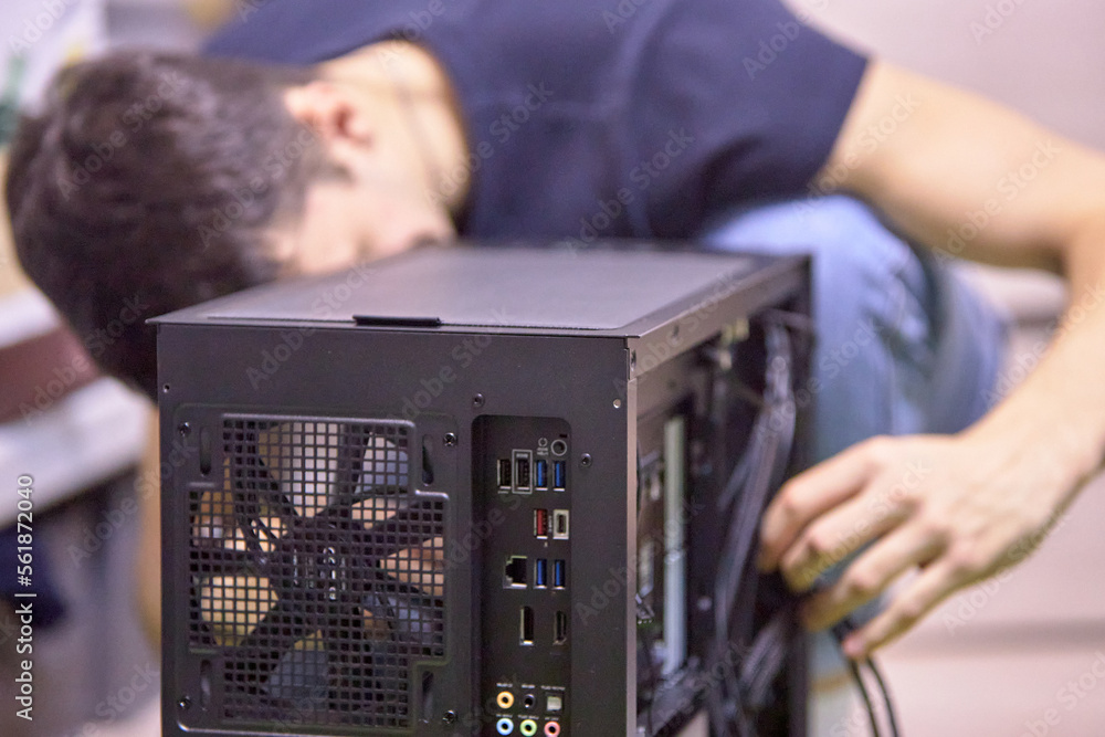 Foto de A young man, builds a new computer from components, cable ...