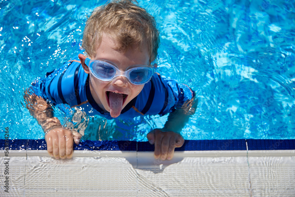 Foto de View from above of a boy sticking out his tongue floating in a ...