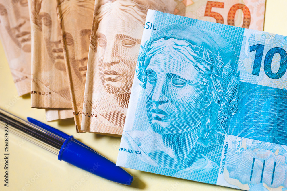 Notas do Real Brasileiro em fotografia macro. Fundo com papel amarelo e ...