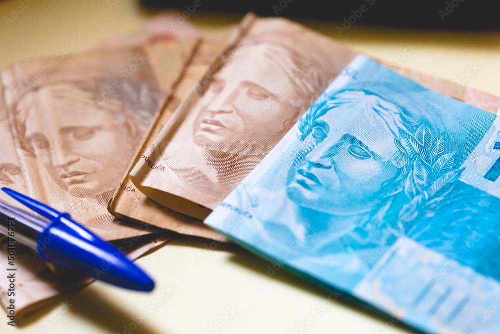 Notas do Real Brasileiro em fotografia macro. Fundo com papel amarelo e ...