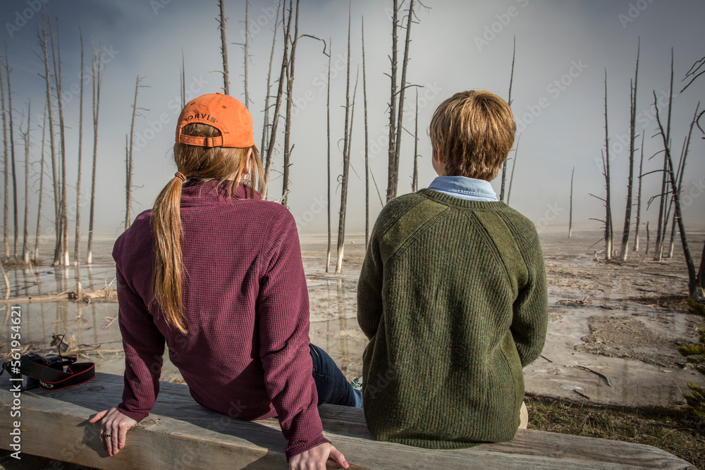 Two women relax while watching geysers in Yellowstone. Stock Photo ...