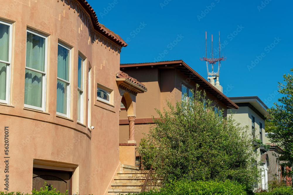 Row of house or home facades with visible windows and front yard trees ...