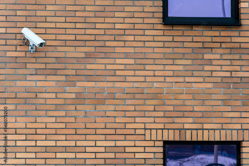 CCTV cameras are installed on the brick wall at the entrance to the ...