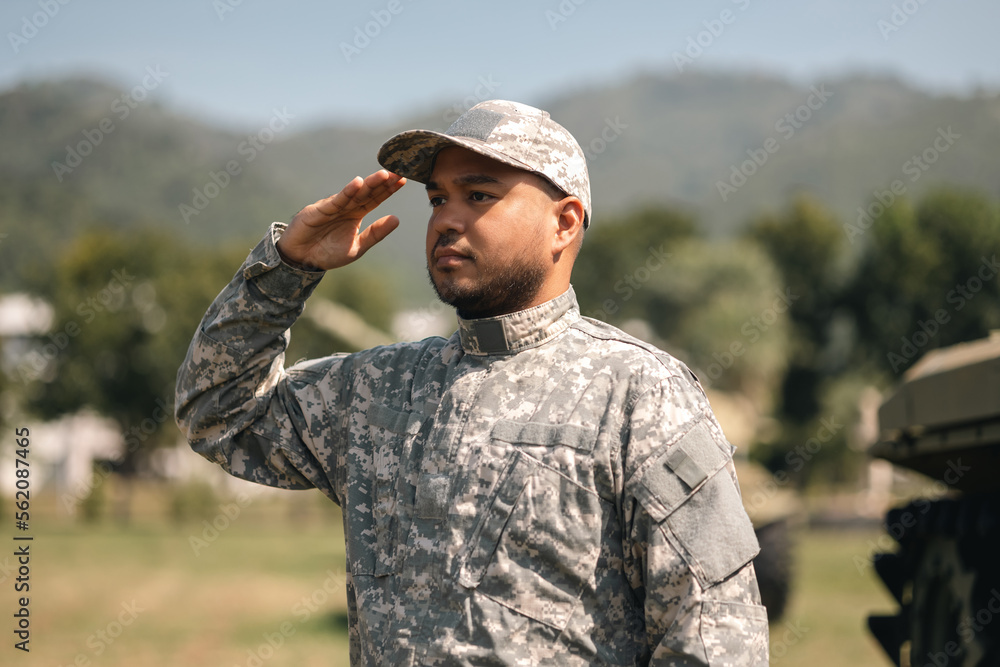 Asian man special forces soldier saluting standing against on the field ...