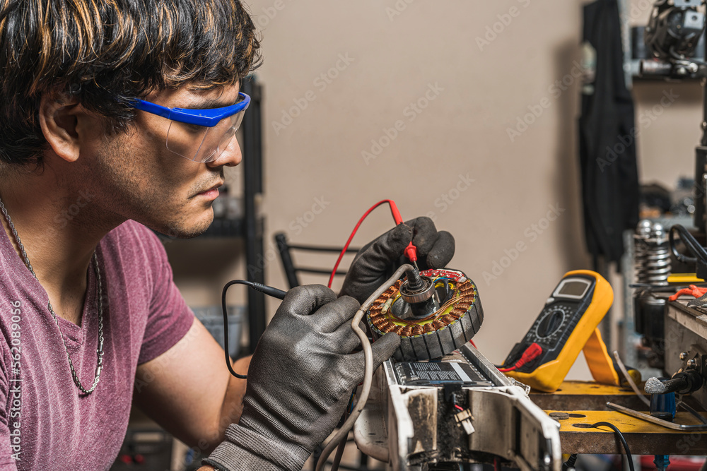 Mechanic using a multimeter to check the voltage of a scooter Stock ...
