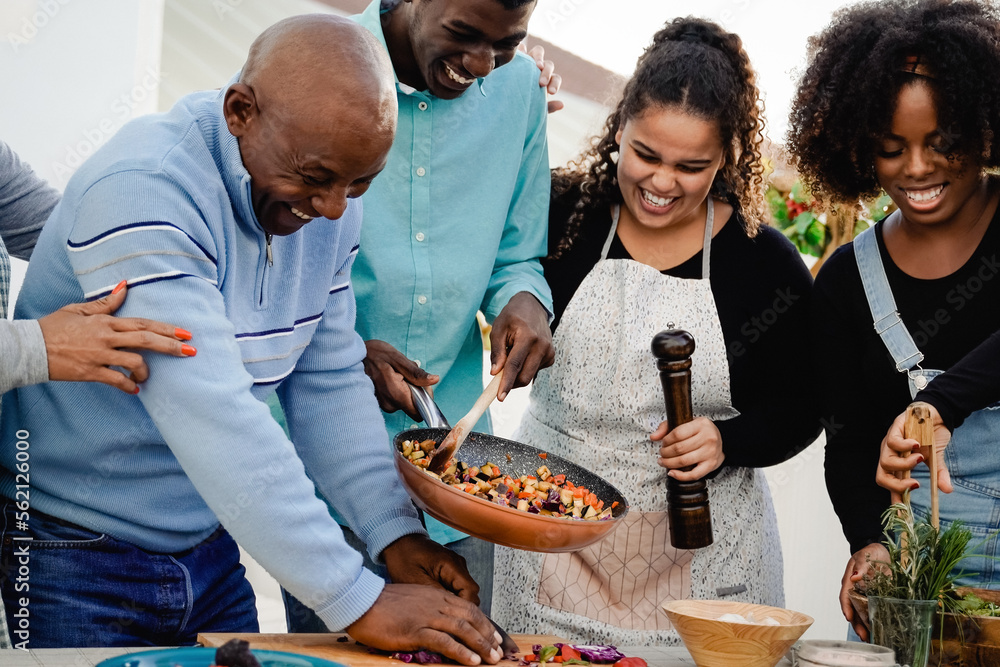 Outdoor kitchen: Happy African family cooking together at home patio ...