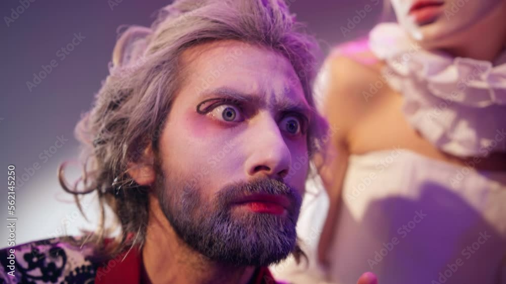 Astonished Caucasian man with theatrical makeup looking away with ...