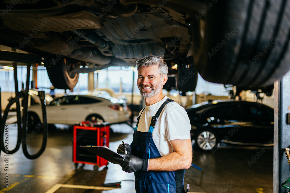 Happy smiling handsome grey hair mechanic at work in his garage. Stock ...