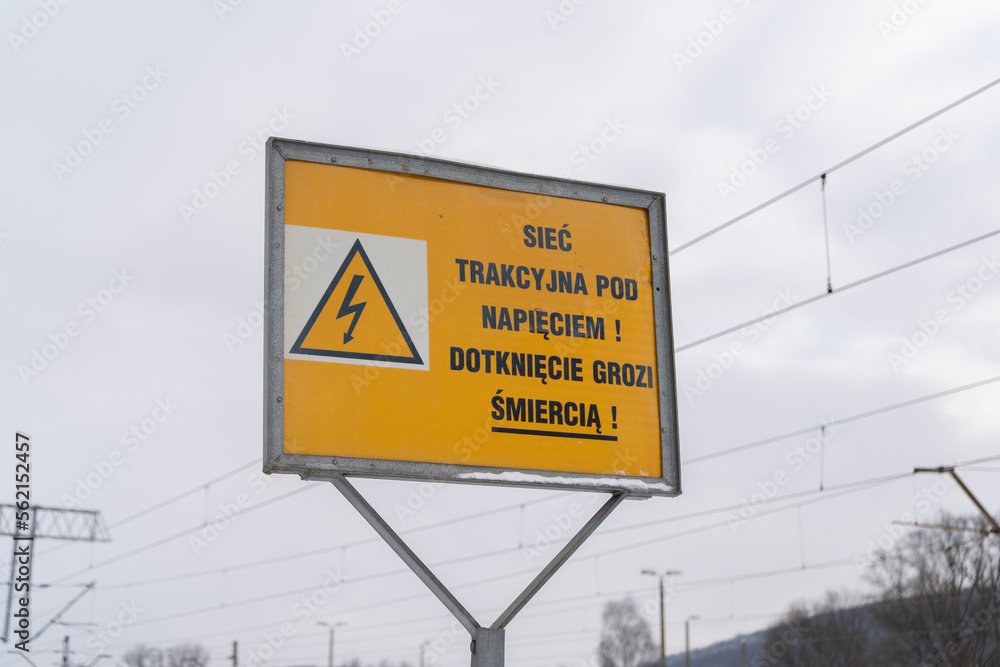 Warning sign with text in Polish language, means overhead electrical ...