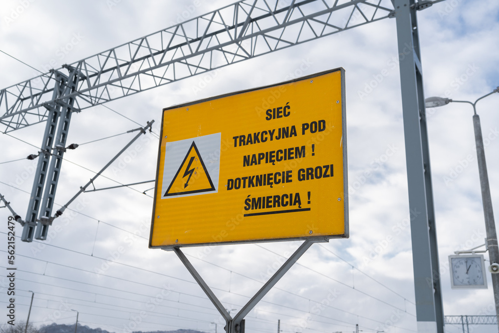 Warning sign with text in Polish language, means overhead electrical ...