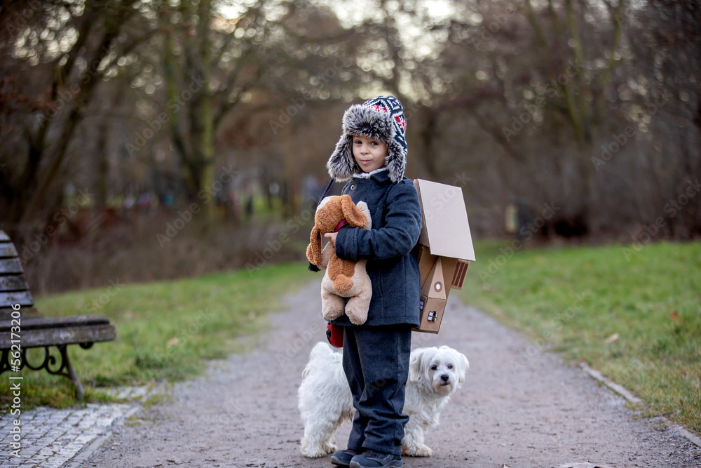 Little child, blond boy with pet dog, carying home on his back, kid ...